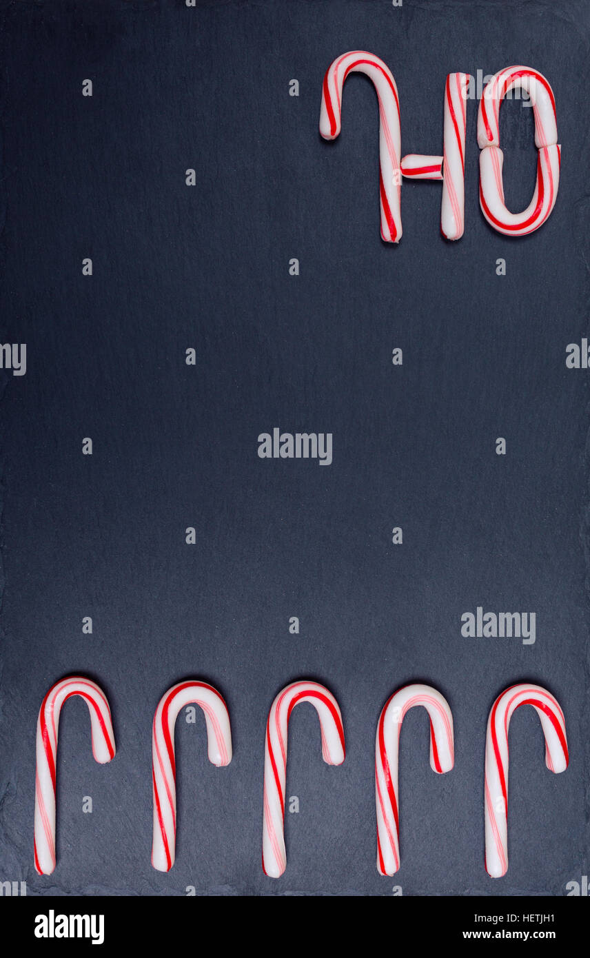Holiday striped candy cane composition on dark stone board background ...