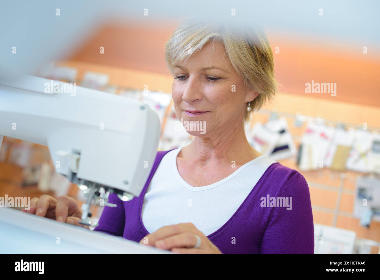 Senior woman using sewing machine Stock Photo - Alamy