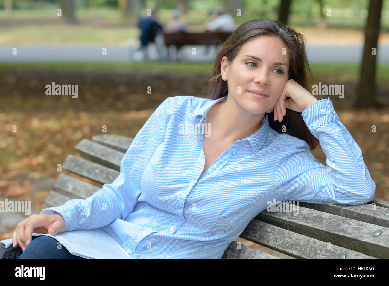 Lady sat on park bench Stock Photo - Alamy