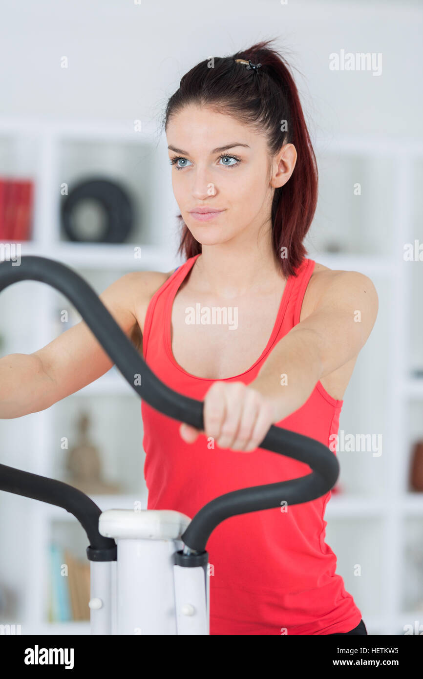 Lady using exercise equipment at home Stock Photo - Alamy