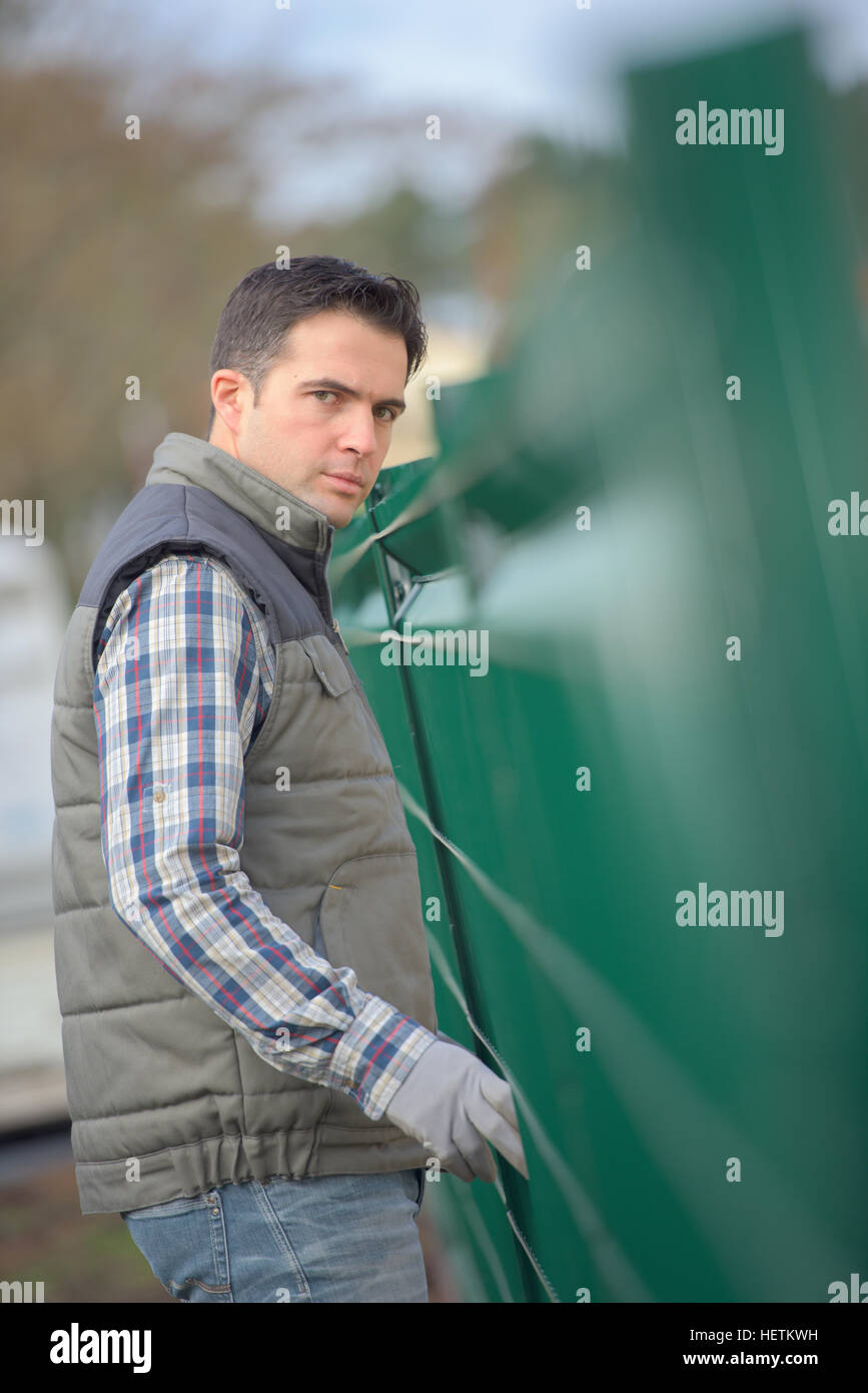 Portrait of man erecting garden fence Stock Photo - Alamy