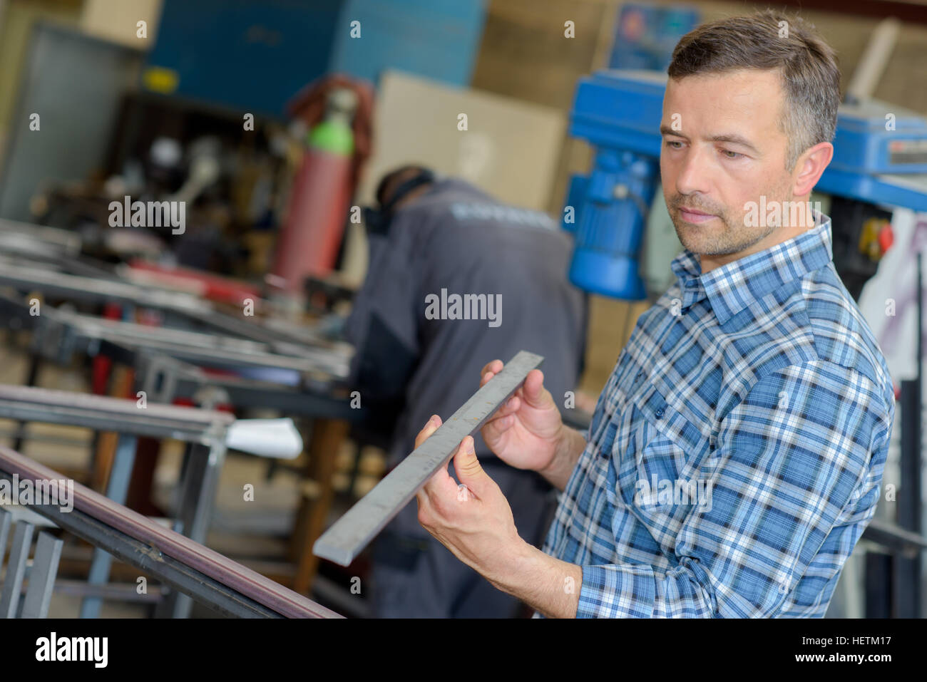 Workman holding metal ruler Stock Photo - Alamy