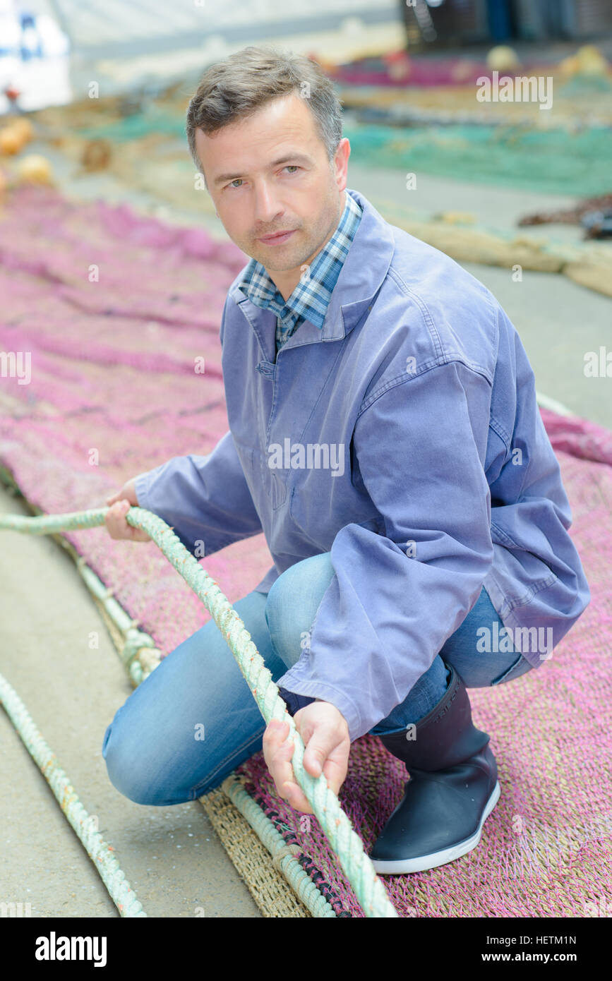 Fisherman holding rope of net Stock Photo - Alamy