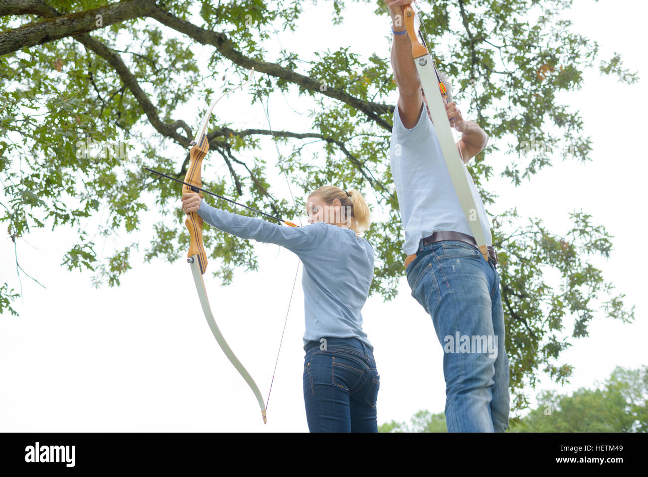 Upward view of people practicing archery Stock Photo - Alamy