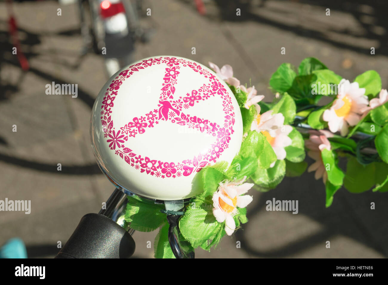 Detail of a bicycle's rounded ring bell with sign of "Peace" drawn on ...