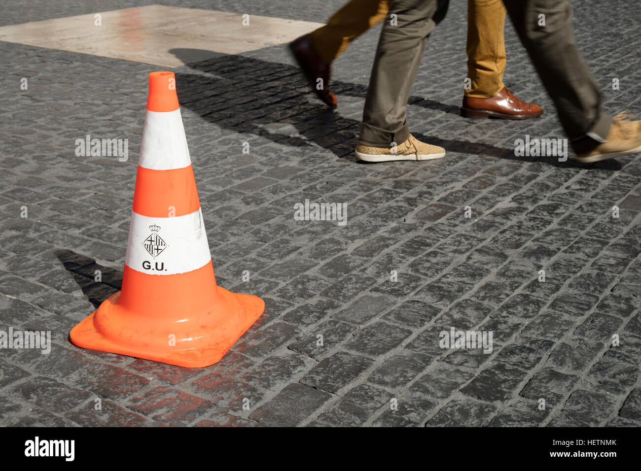 Detail of traffic cone with coat of arms of Barcelona City and people ...