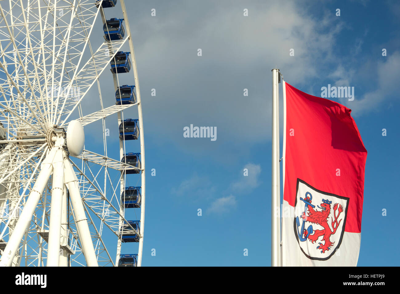 Ferris wheel and flag of Düsseldorf flag with blue cloudy background ...