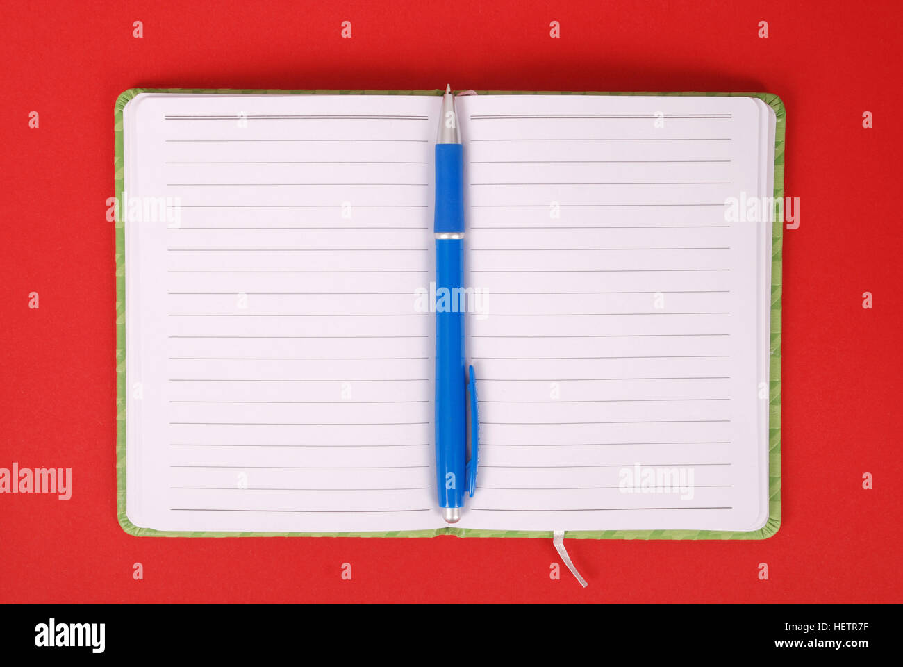 Green open notebook with blue pen isolated on white background red soft ...