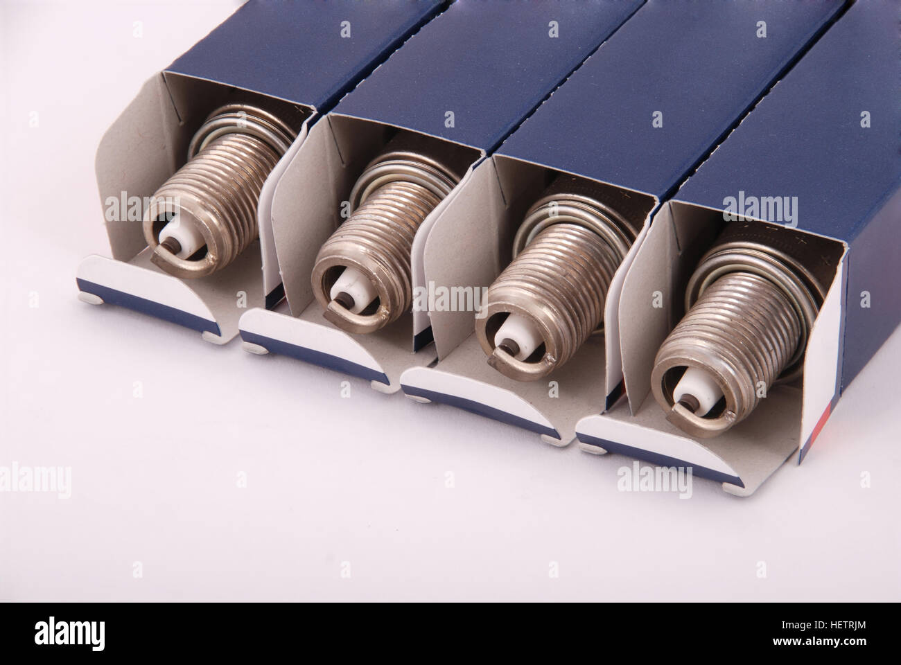 Four new spark plugs in paper packaging on a gray background Stock ...