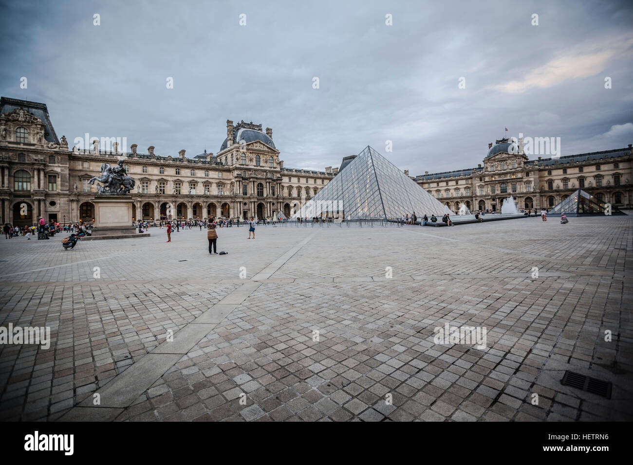 Louvre museum at dusk in Paris. This is one of the most popular tourist ...