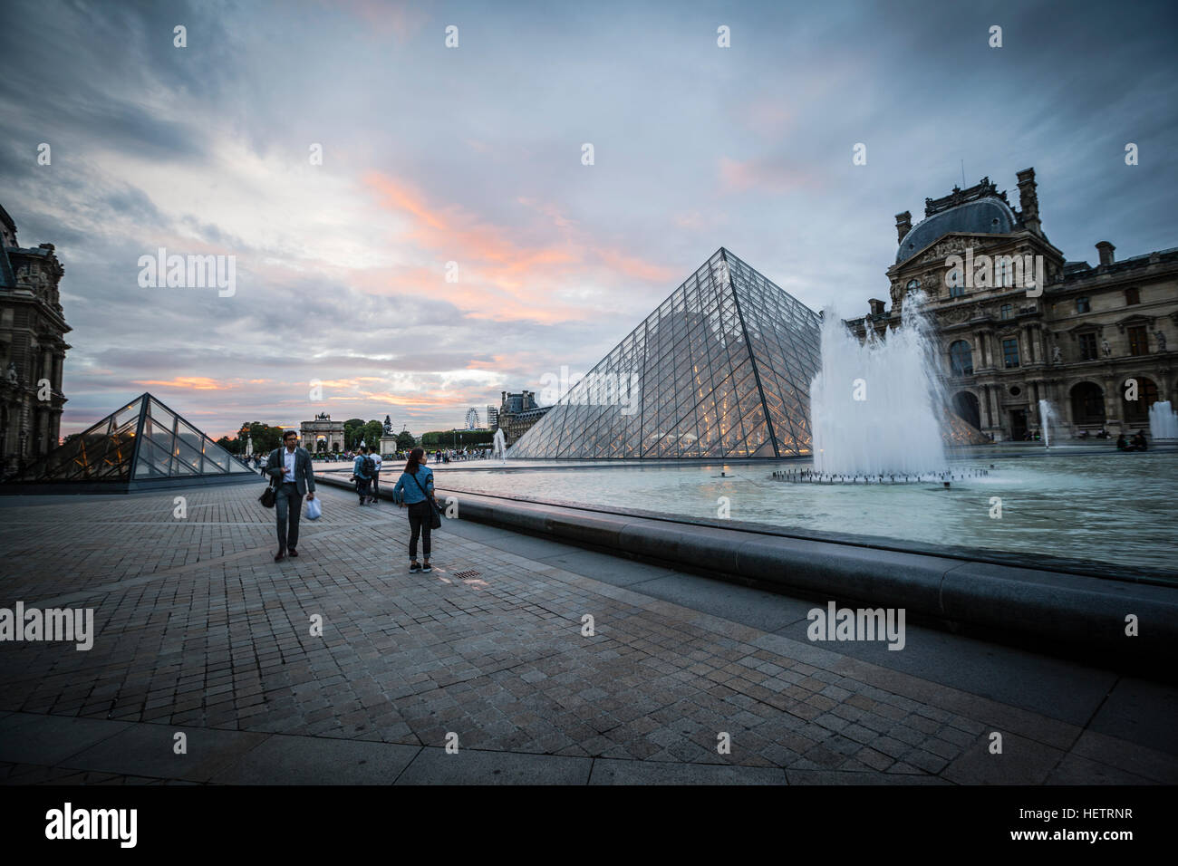Louvre museum at dusk in Paris. This is one of the most popular tourist ...