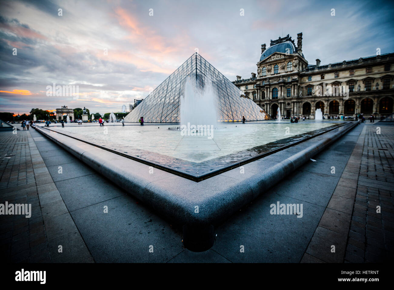 Louvre museum at dusk in Paris. This is one of the most popular tourist ...