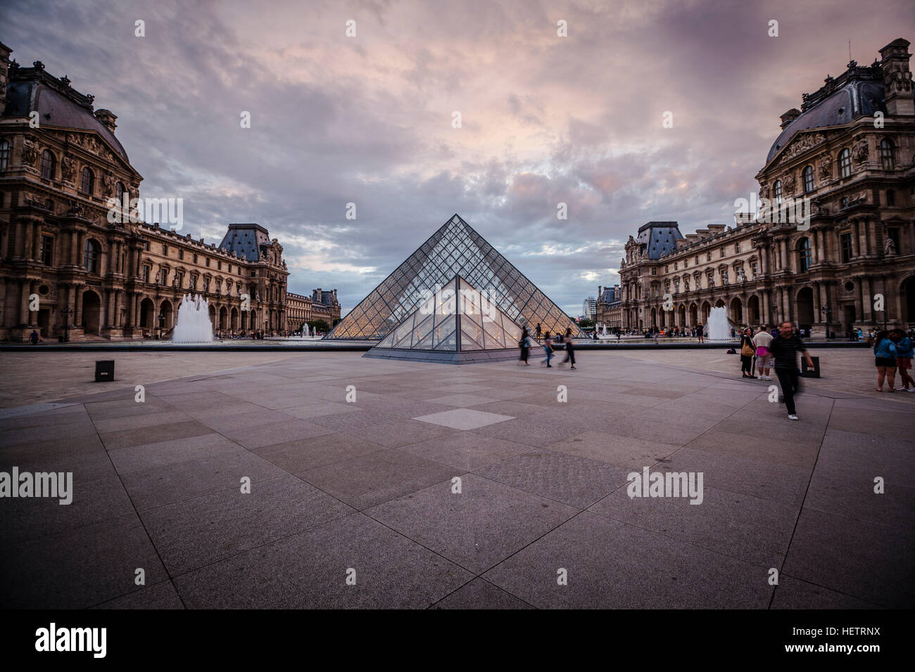 Louvre museum at dusk in Paris. This is one of the most popular tourist ...