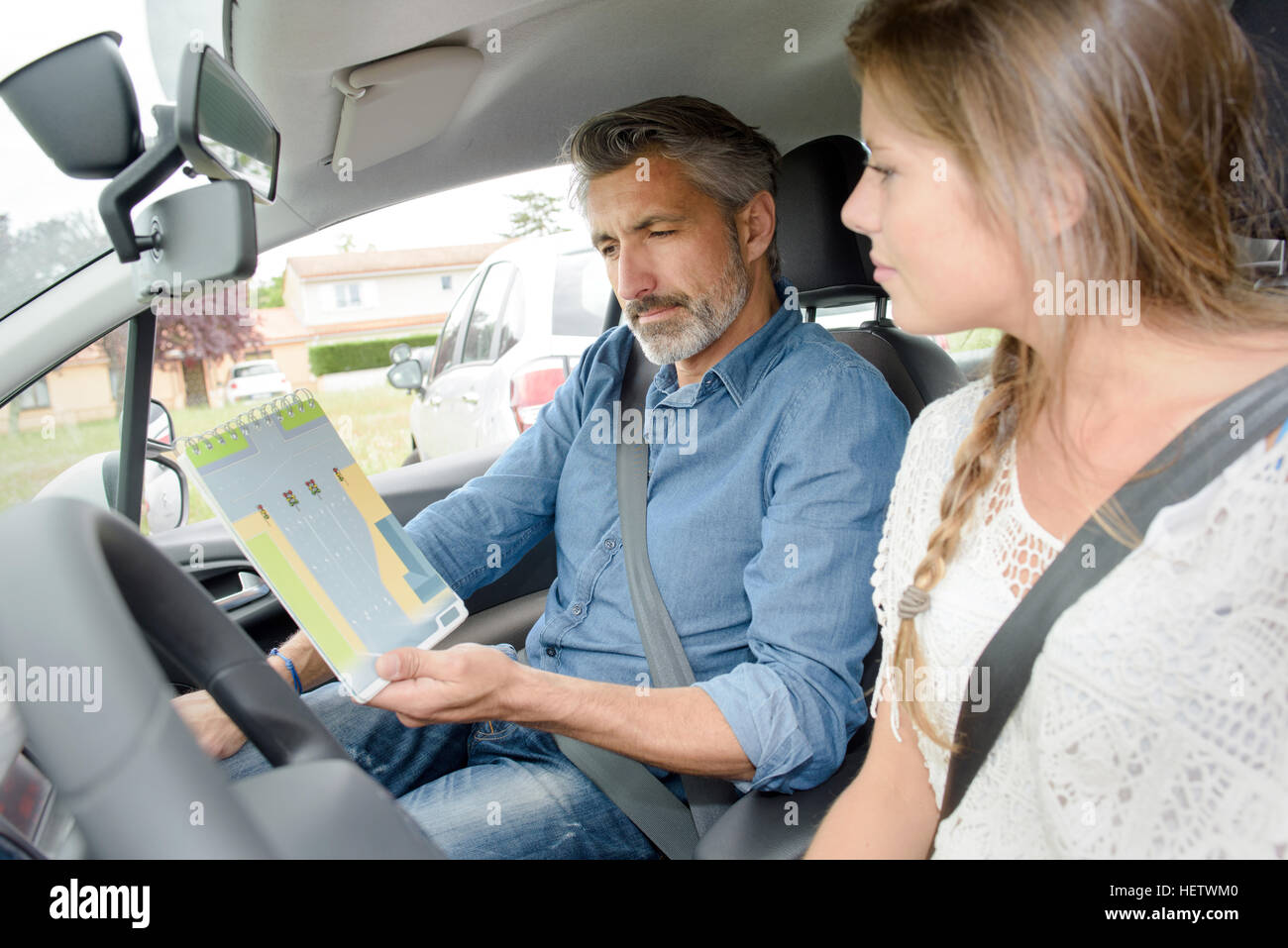 Lady with driving instructor, learning theory Stock Photo - Alamy