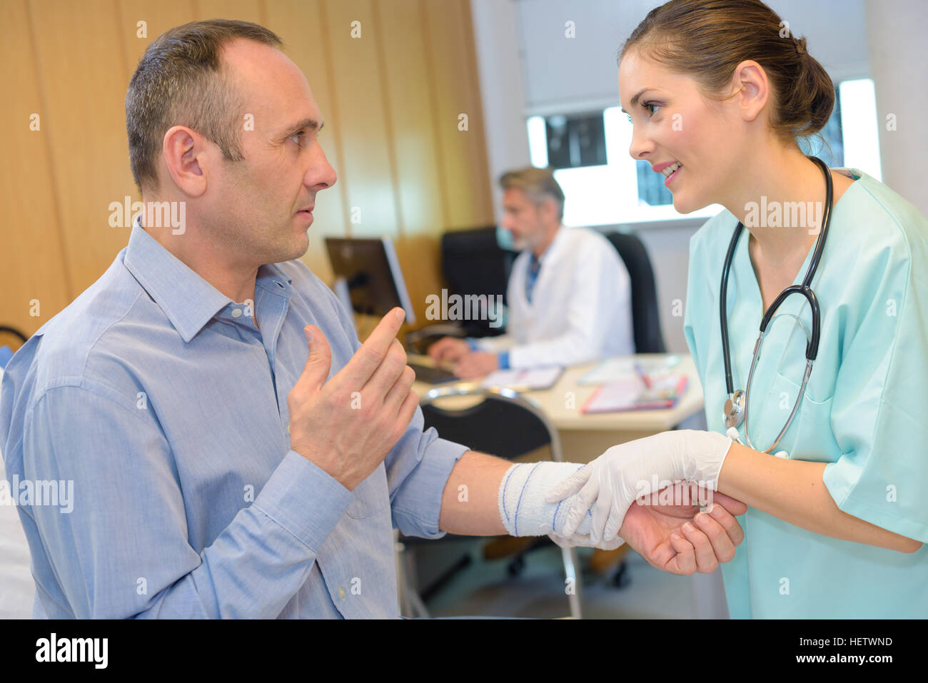 Nurse bandaging patient's wrist Stock Photo - Alamy