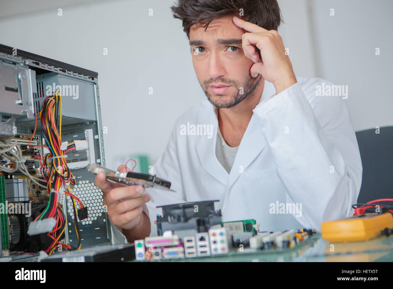 Anguished man with dismantled computer Stock Photo - Alamy