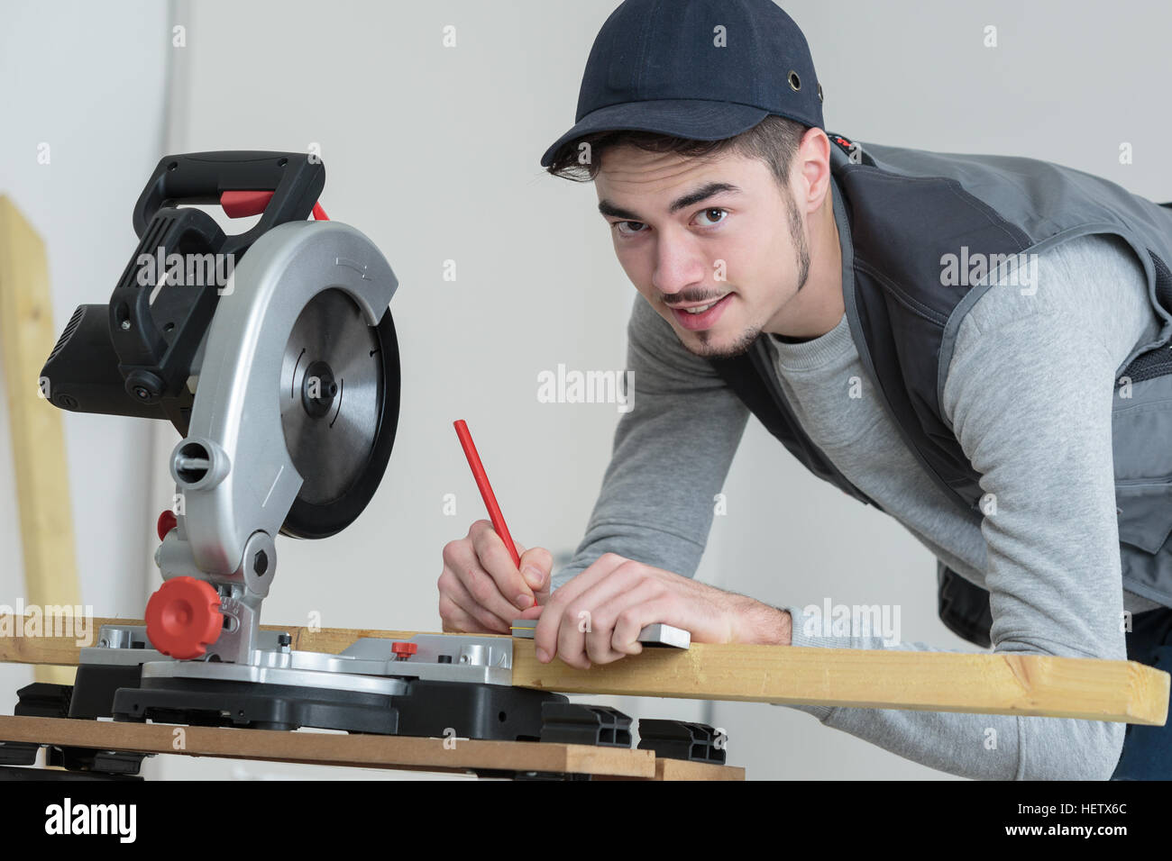 young carpenter using circular saw for wood inside warehouse Stock ...