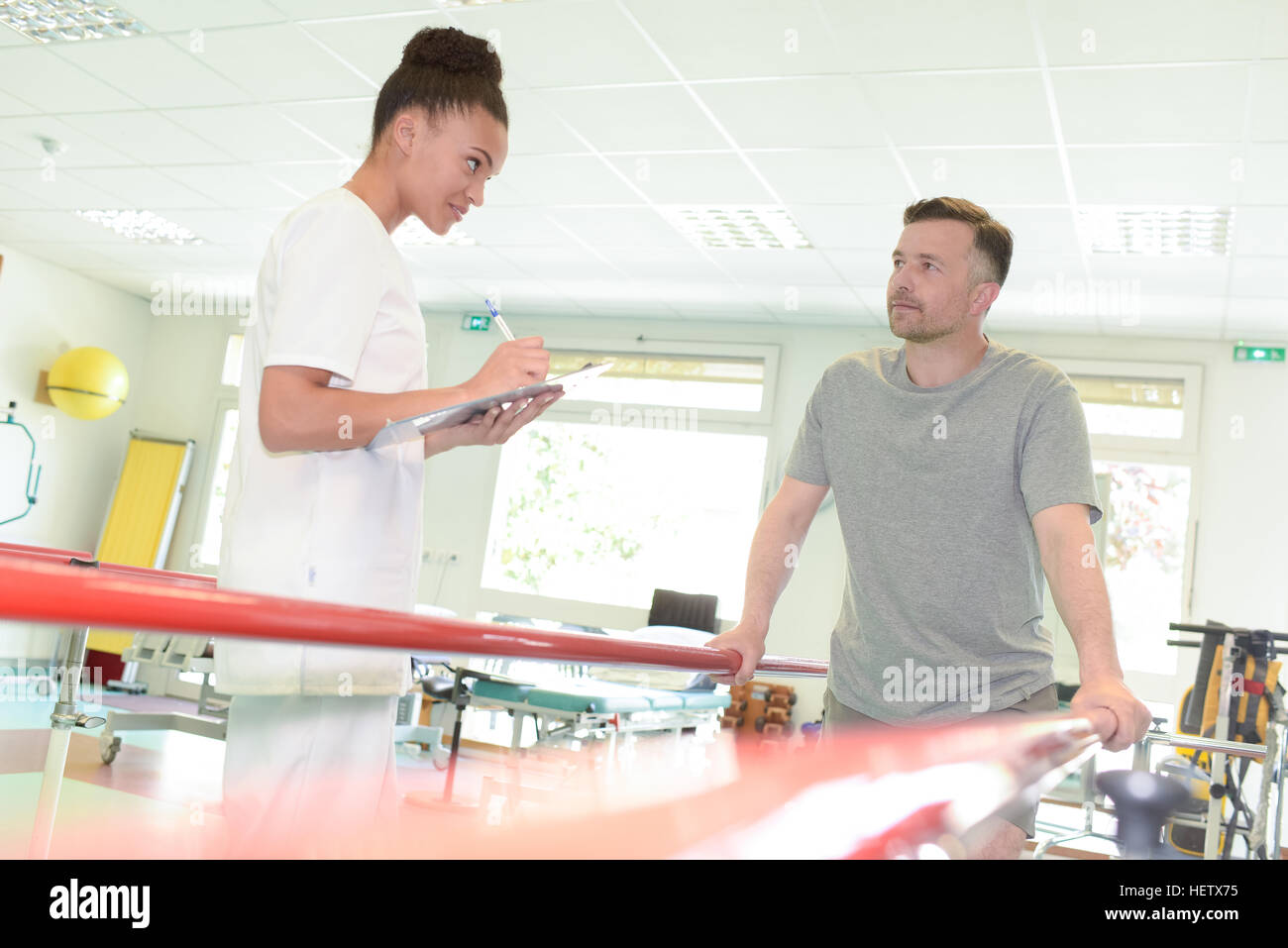 Man walking with aid of bars Stock Photo - Alamy