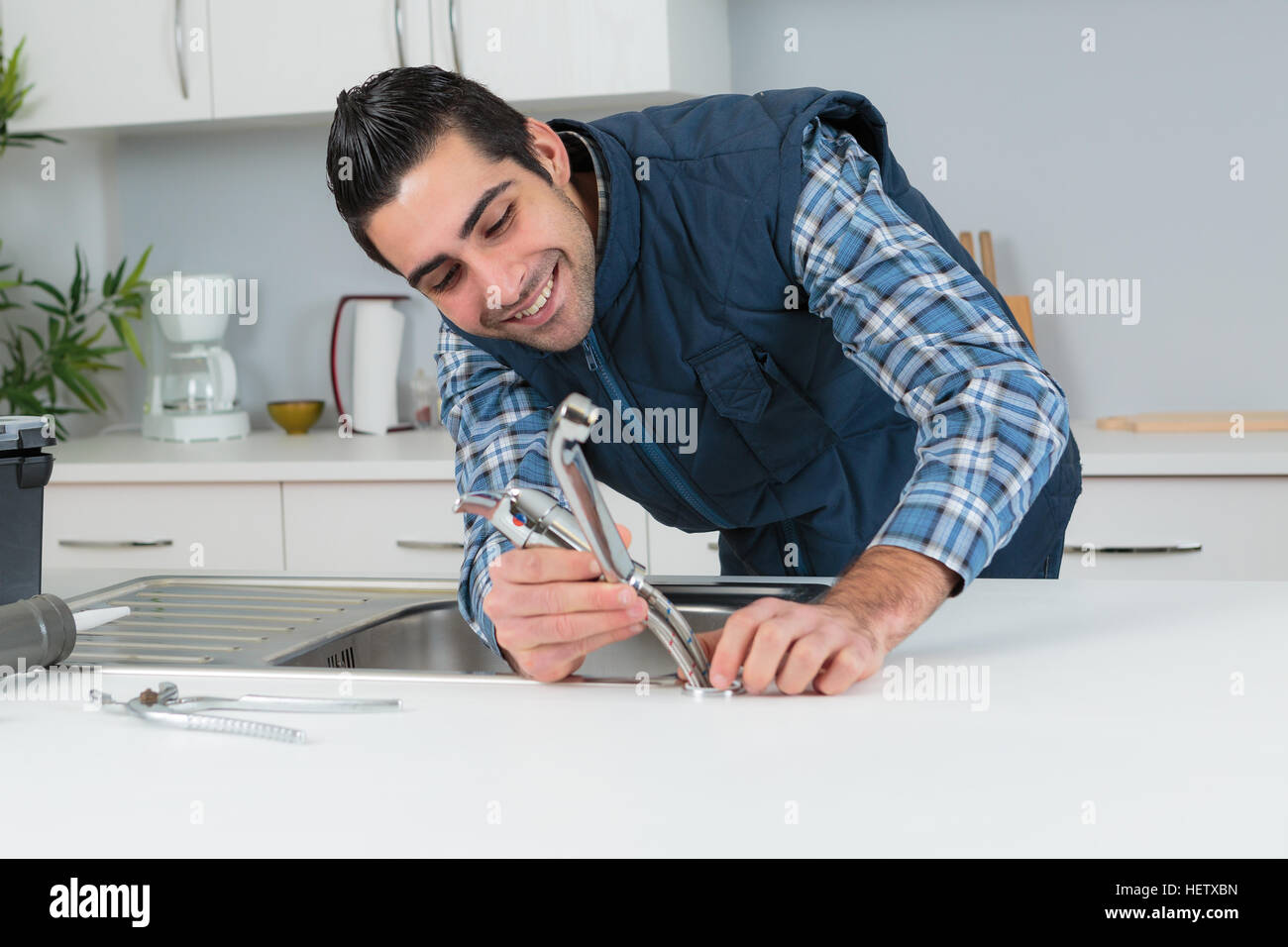 plumber fixing a faucet Stock Photo - Alamy