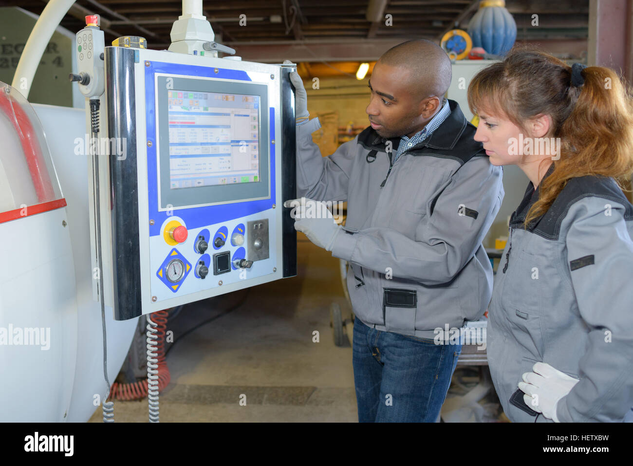 colleagues in front of a machine Stock Photo - Alamy