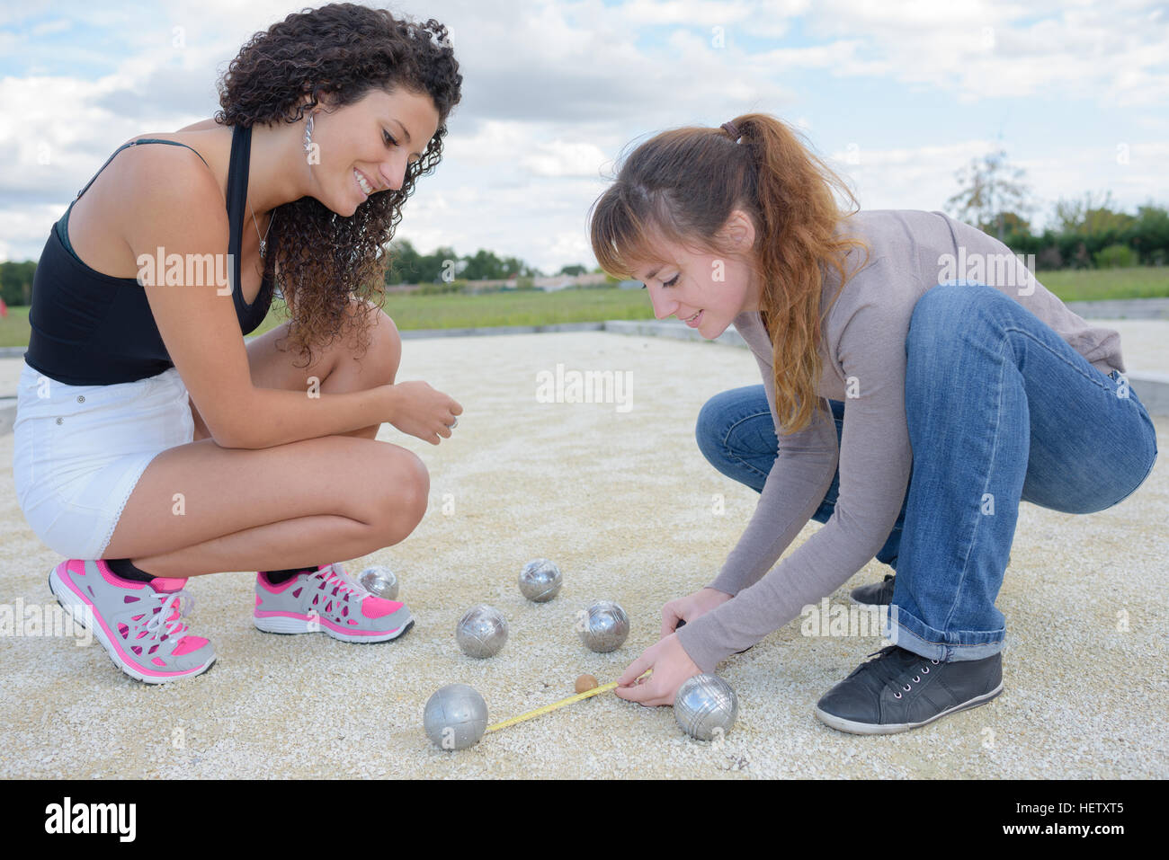 Women measuring distance between bowls Stock Photo - Alamy