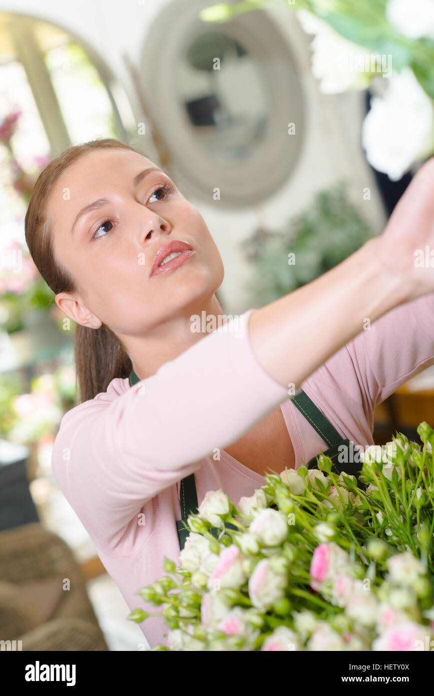 Florist reaching up Stock Photo - Alamy
