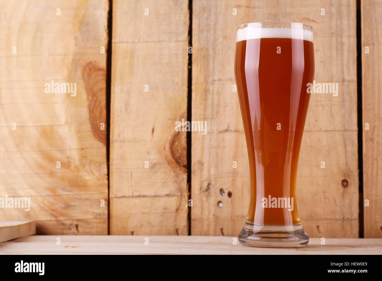 Tall glass full of light beer over a textured wood background Stock ...