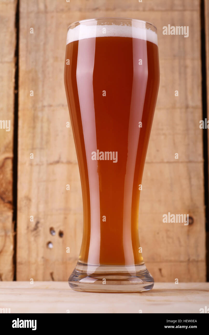 Tall glass full of light beer over a textured wood background Stock ...