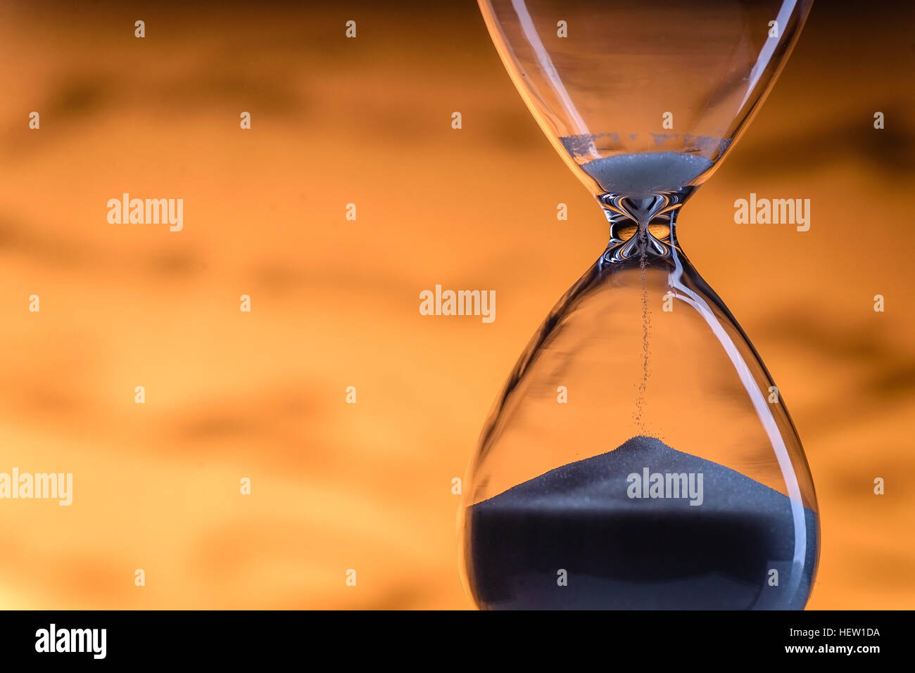 Sand running through an hourglass measuring passing time counting down ...