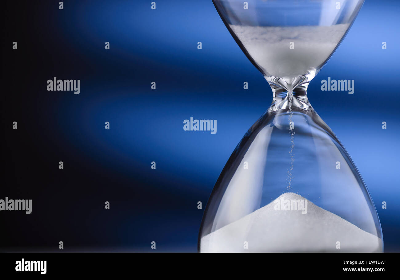 Sand running through an hourglass measuring passing time counting down ...