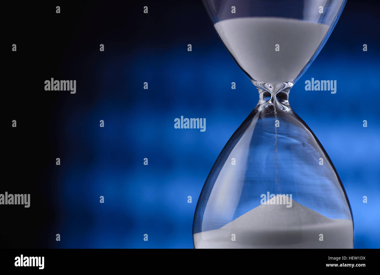 Sand running through an hourglass measuring passing time counting down ...