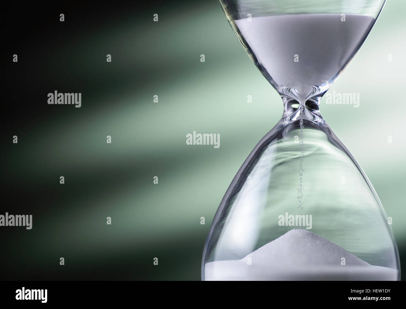 Sand running through an hourglass measuring passing time counting down ...