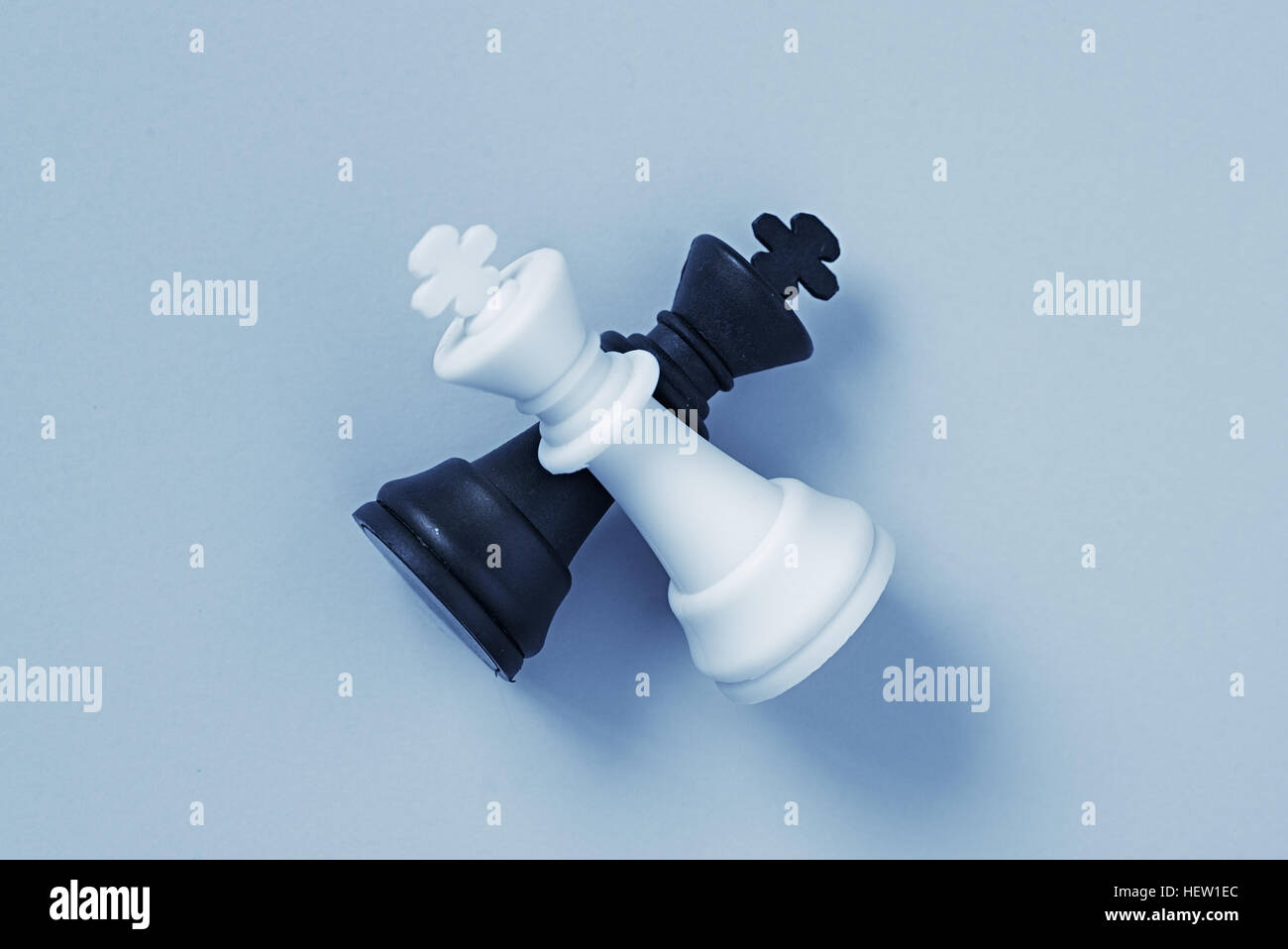 Two chess kings lying on a light blue background with slight set shadow ...