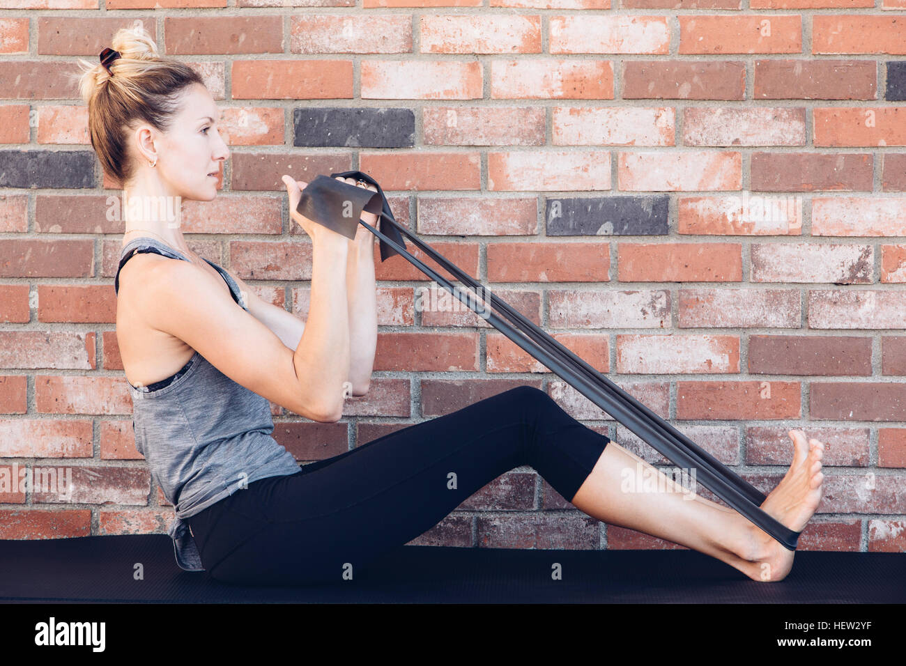 Side view of woman using resistance band Stock Photo - Alamy