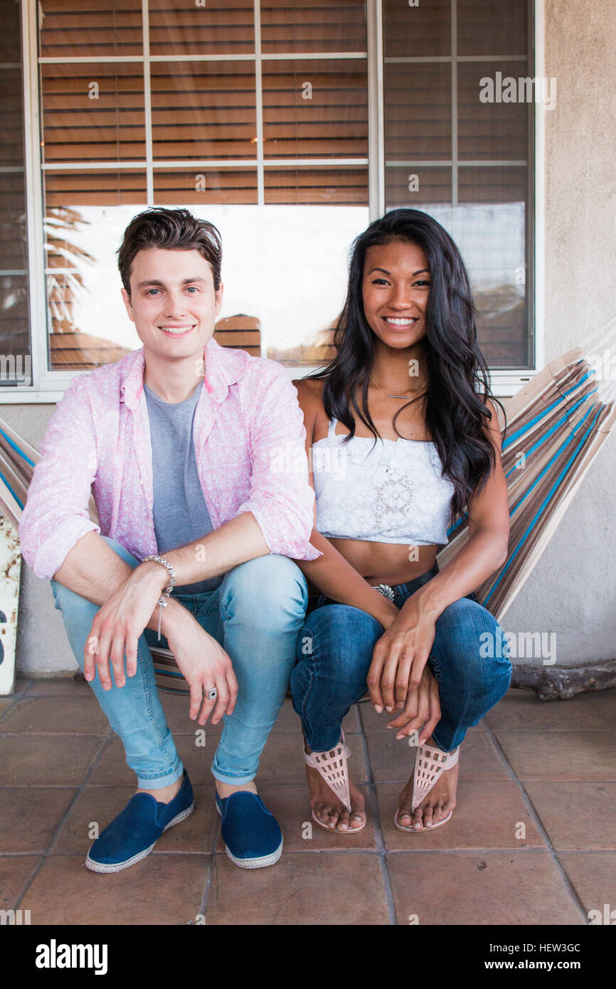 Portrait of young couple relaxing on veranda, sitting on hammock Stock ...