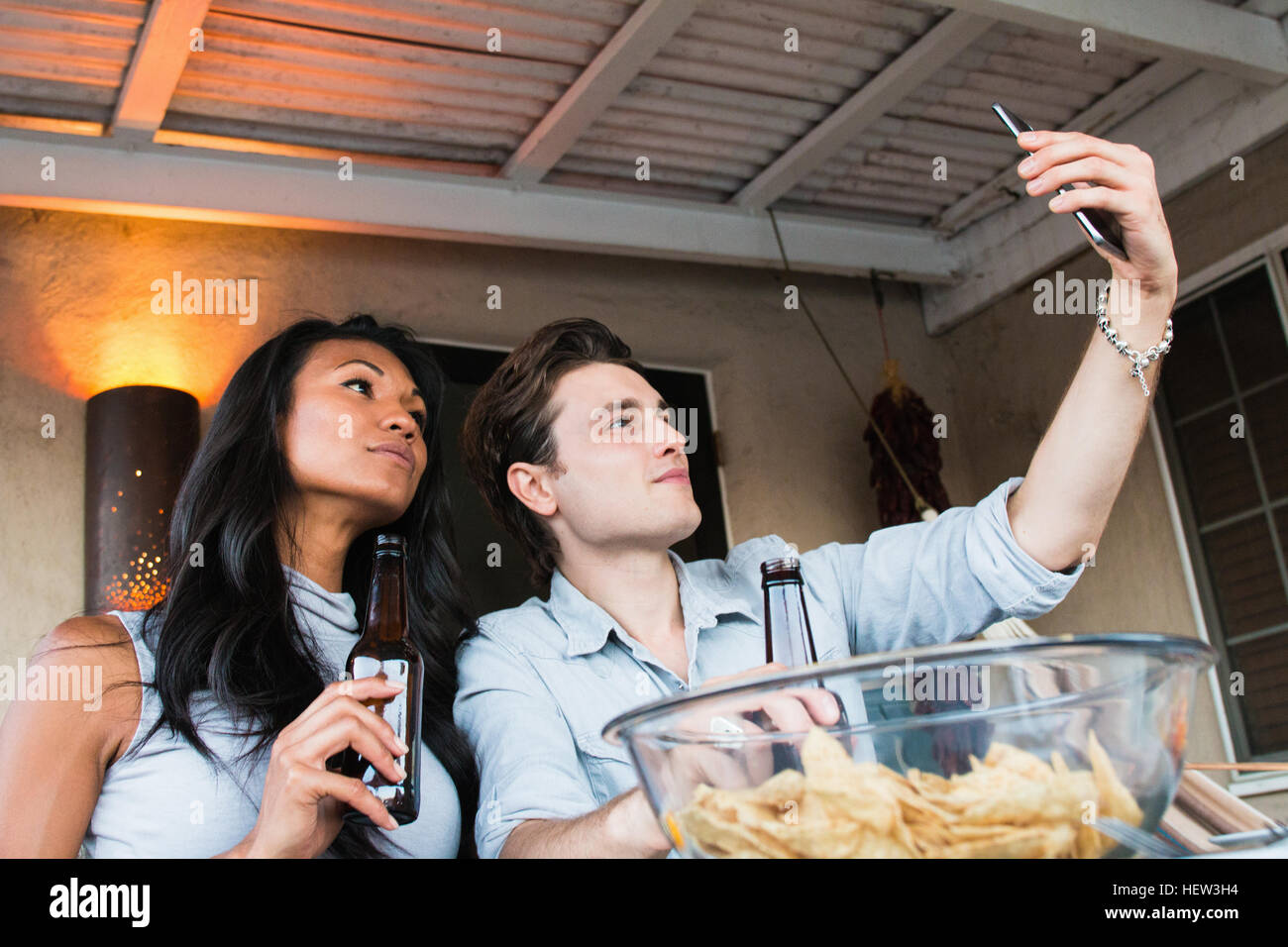 Young couple sitting on veranda, taking selfie, using smartphone Stock ...