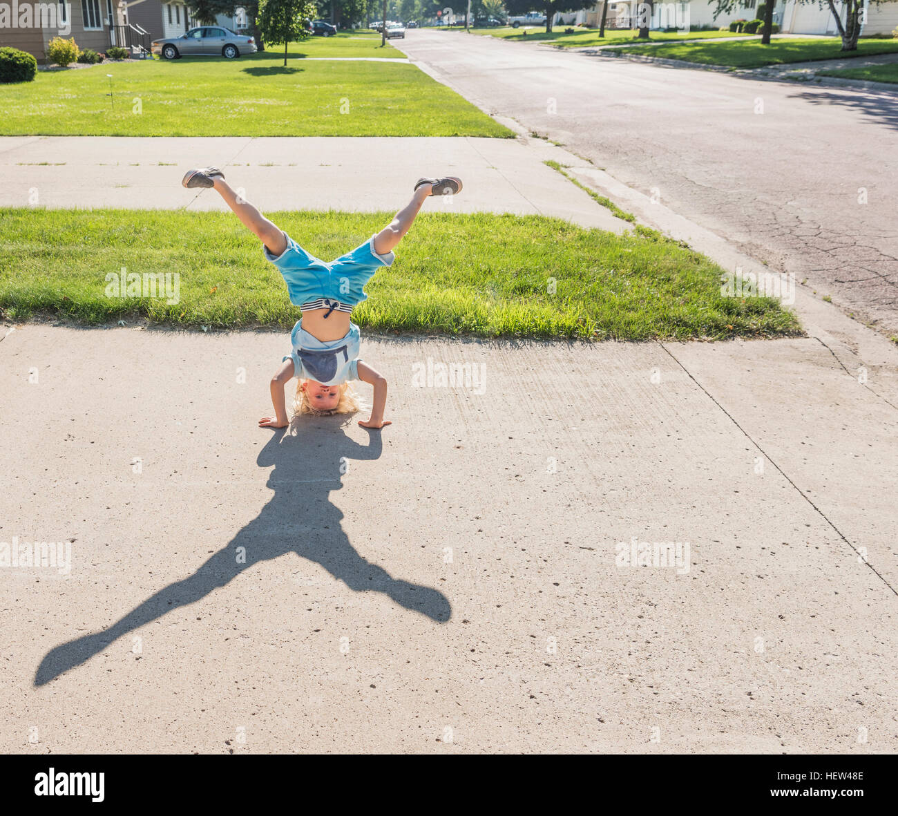 Boy doing handstand on driveway Stock Photo - Alamy