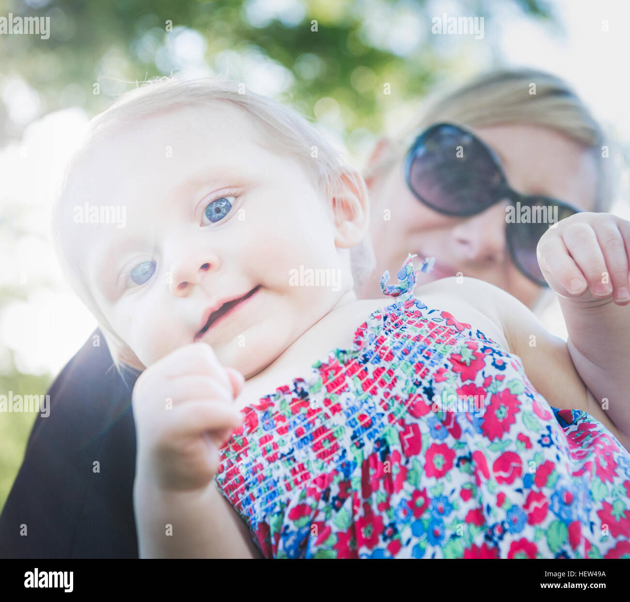 Mother and baby girl looking at camera Stock Photo - Alamy