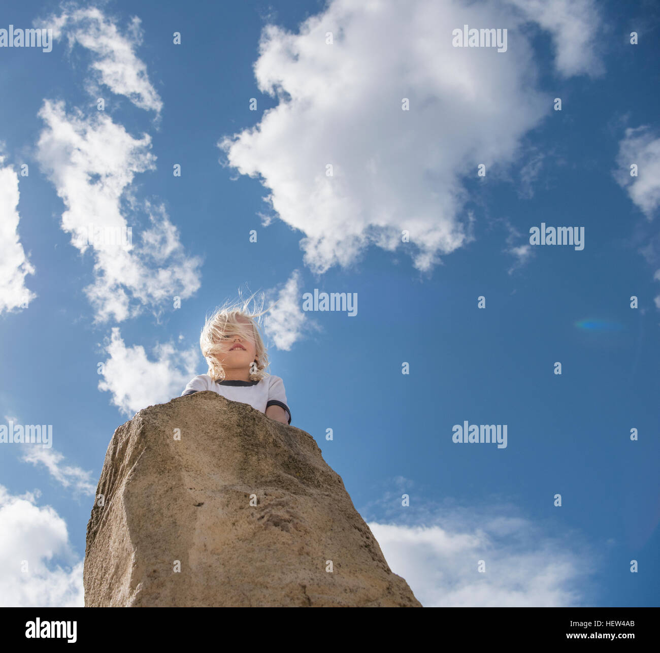 Boy on top of rock looking away Stock Photo - Alamy
