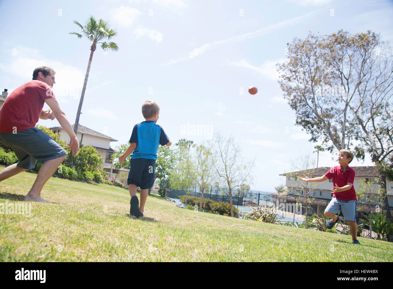 Man and two sons practicing american football in park Stock Photo - Alamy