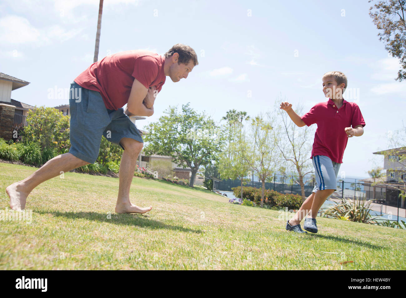 Man and son practicing american football in park Stock Photo - Alamy