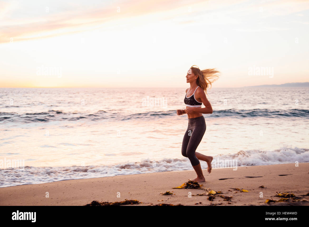 Woman jogging on beach Stock Photo - Alamy
