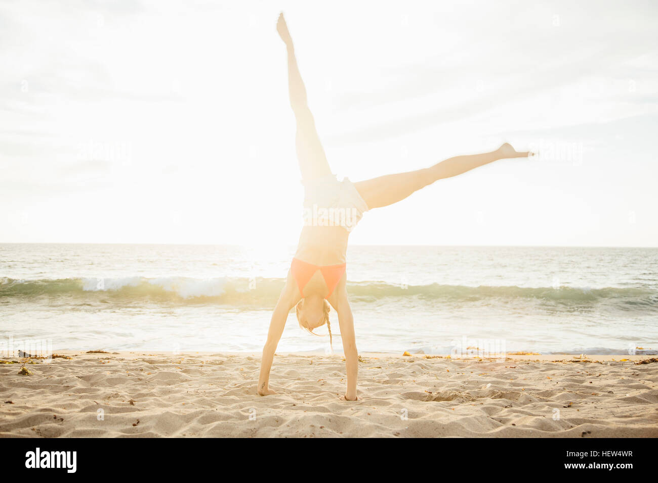 Woman on beach doing handstand Stock Photo - Alamy