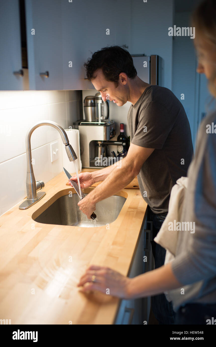 Mid adult couple washing kitchen knife at kitchen sink Stock Photo - Alamy