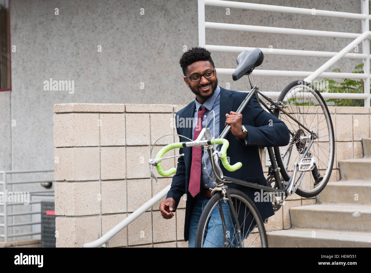Young man carrying bicycle down steps Stock Photo - Alamy