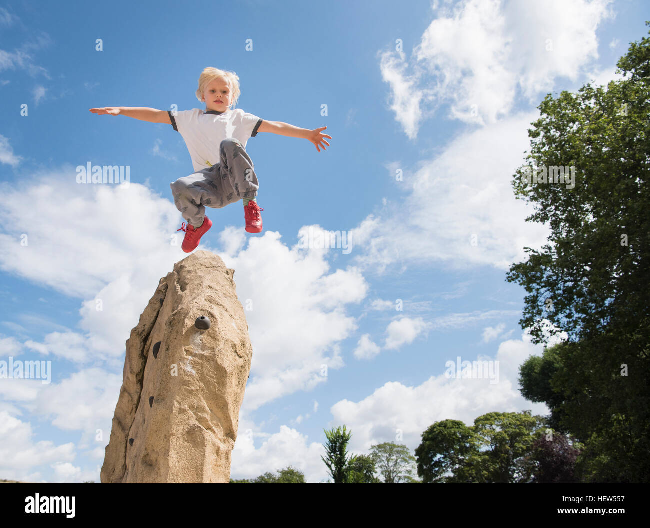 Boy jumping from rock Stock Photo - Alamy