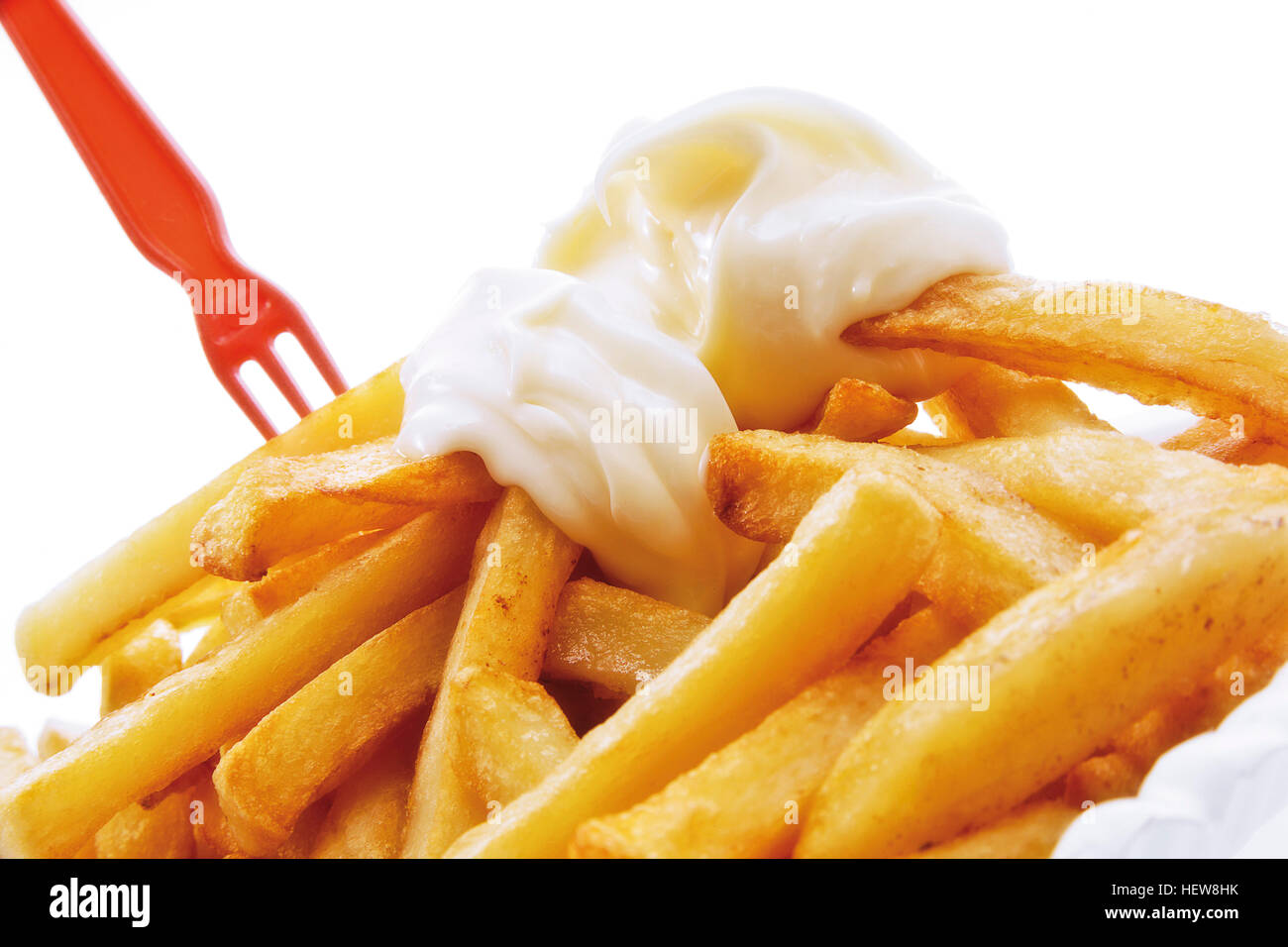 French fries and mayonnaise and small red plastic fork on a paper plate ...