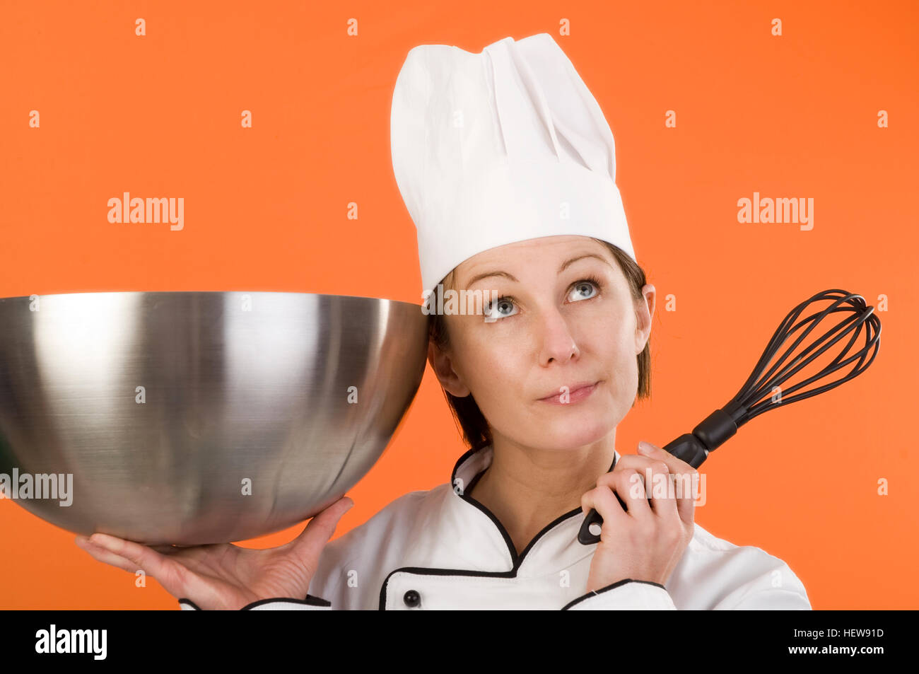 Young female chef holding a mixing bowl and whisk Stock Photo - Alamy