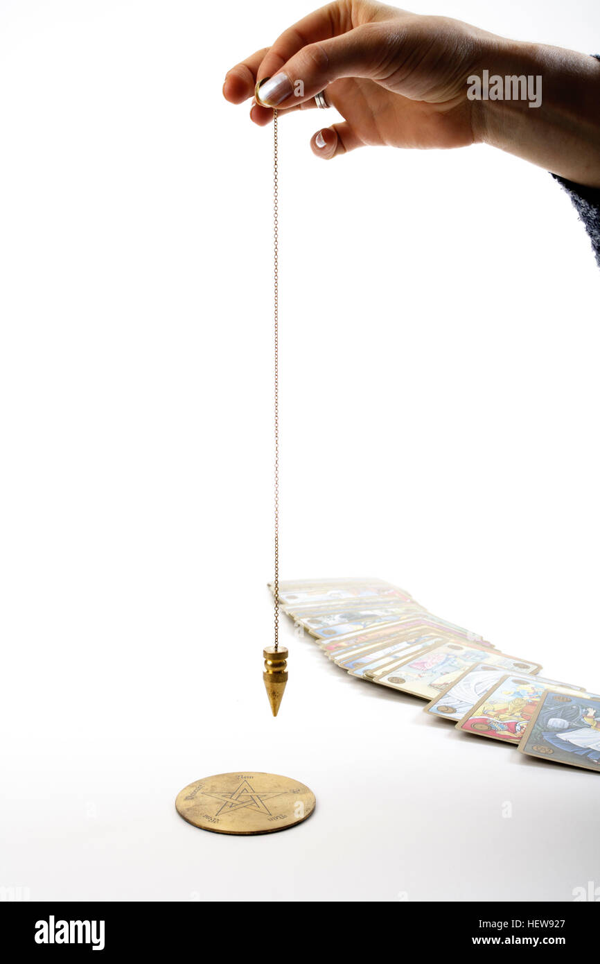 Hand holding pendulum, fortune telling with fortune telling cards Stock ...