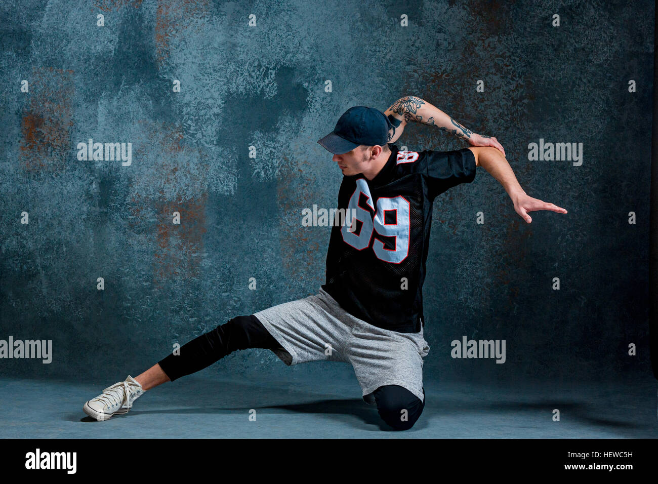 Young man break dancing on blue studio background Stock Photo - Alamy